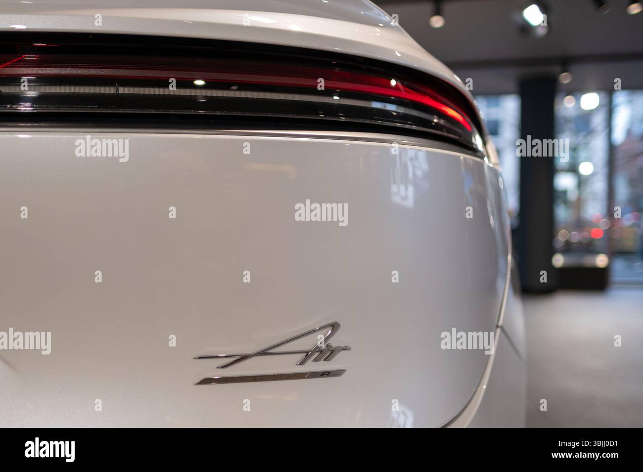 close-up white Lucid Air's rear quarter panel, "Air" badge, battery ...