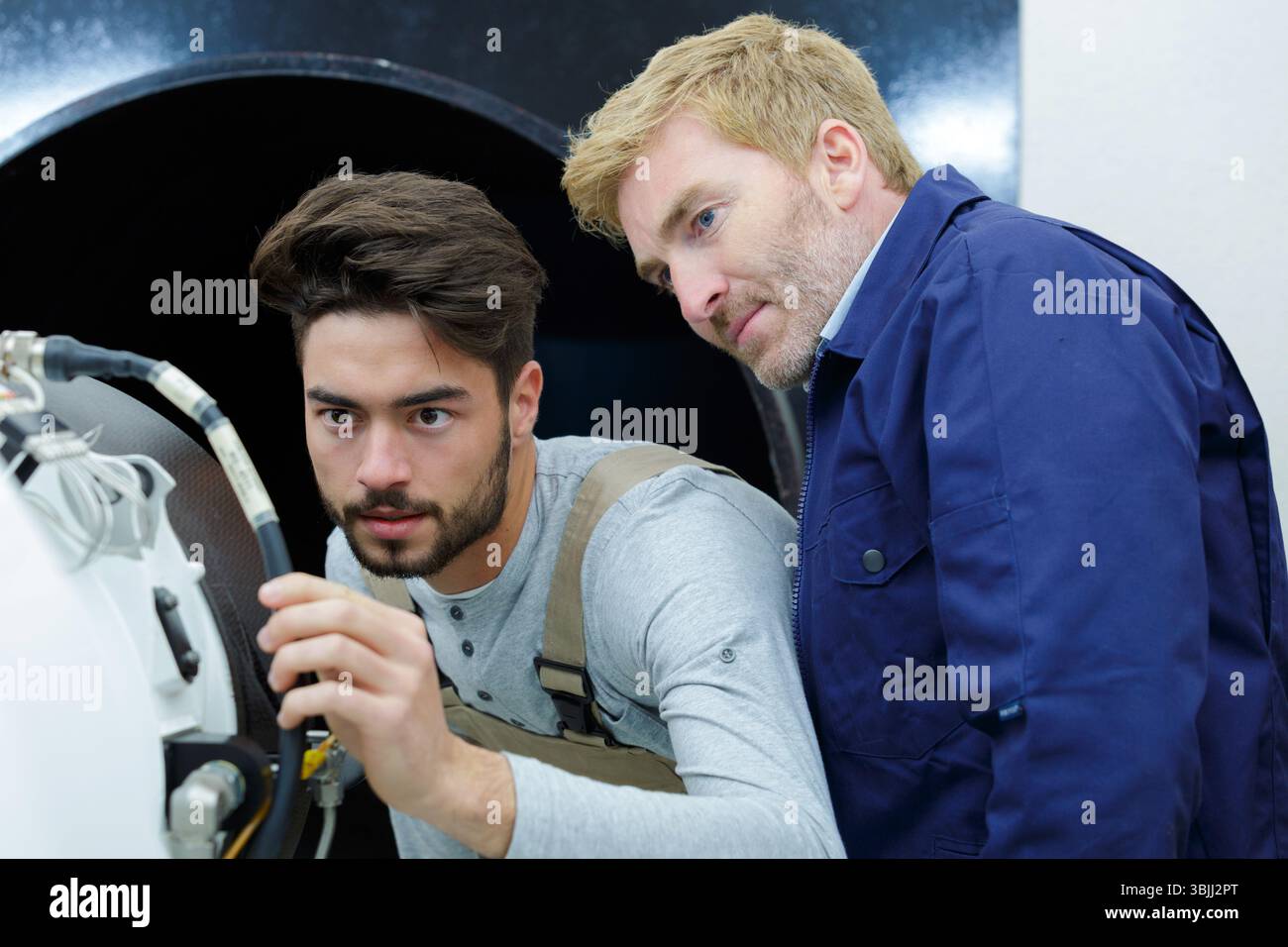 two man worker in piping in factory Stock Photo - Alamy