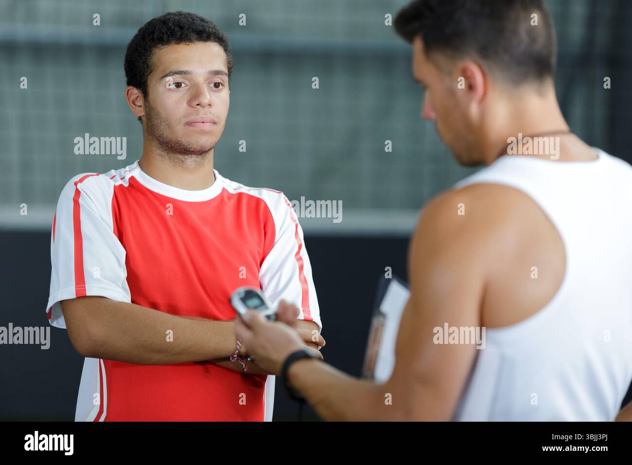 coach holding a stopwatch with footballer Stock Photo - Alamy
