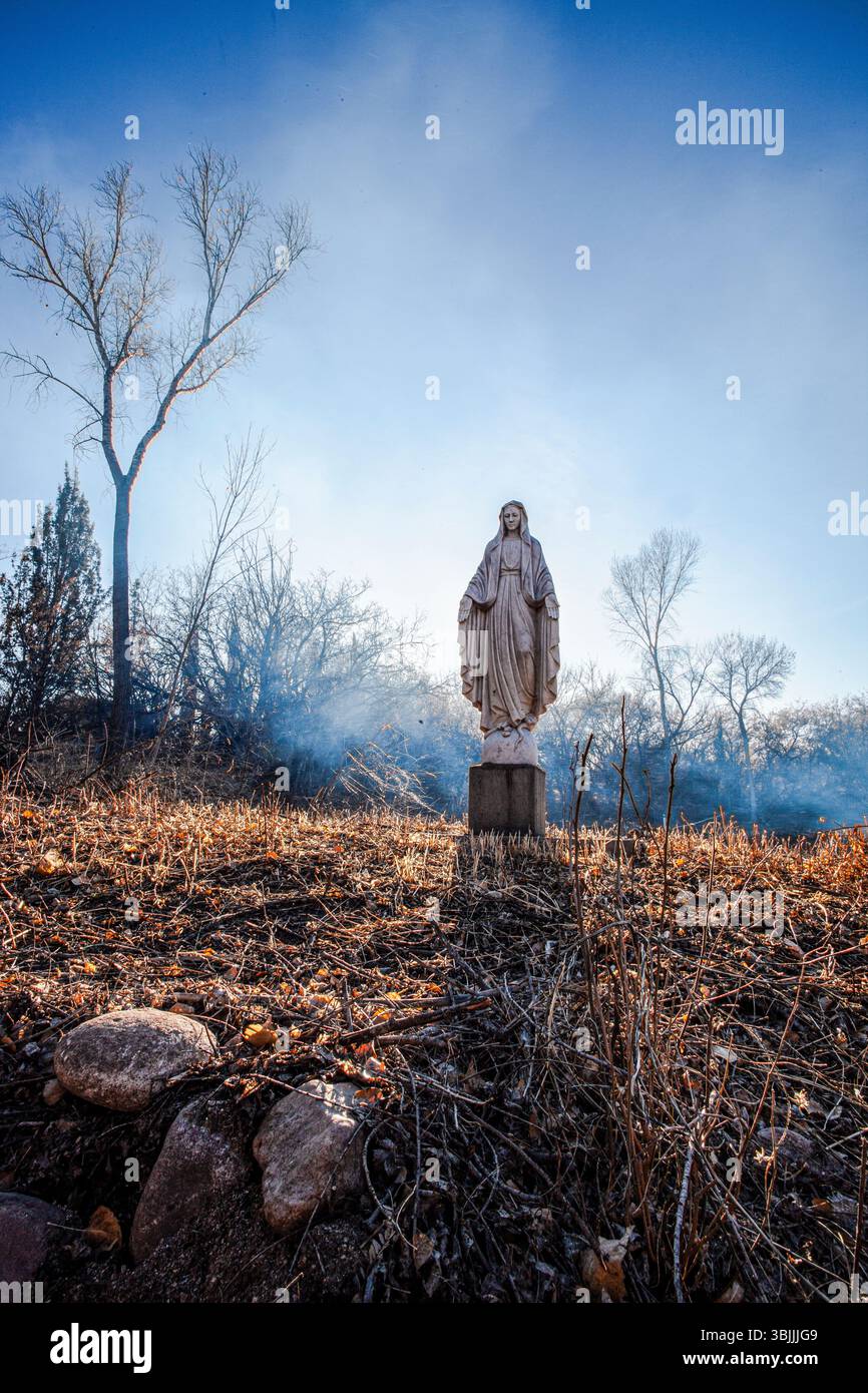 Statue of Mary in burning field vertical Stock Photo - Alamy