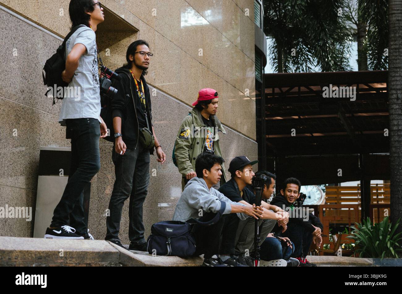 Group of young photographers resting outside urban building Stock Photo ...