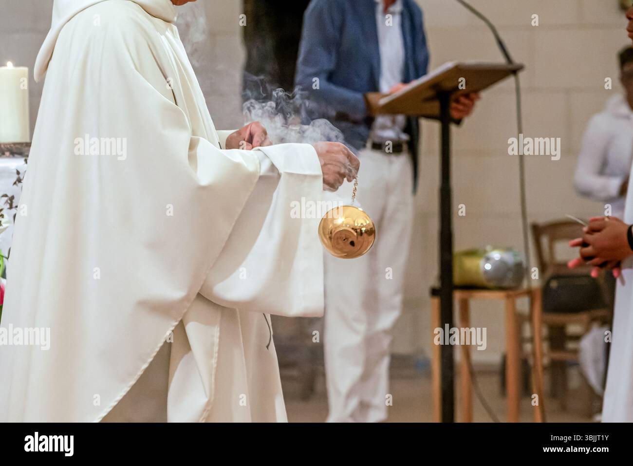 A priest holding a microphone and reading from liturgical texts during ...