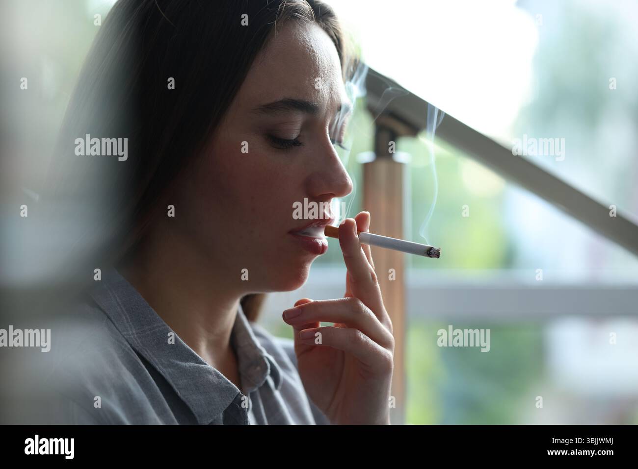 Woman smoking cigarette indoors, closeup. Bad habit Stock Photo - Alamy