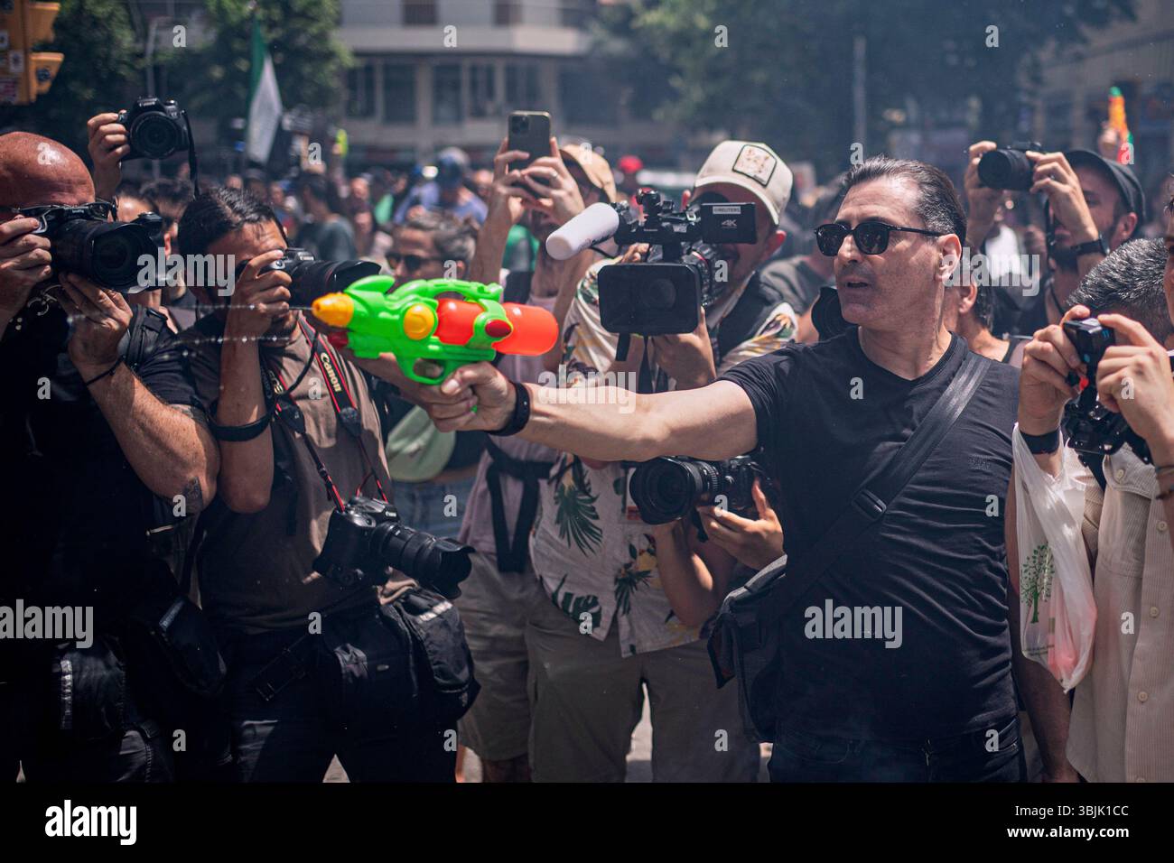 A protester holds a water gun during a protest against overtourism in ...