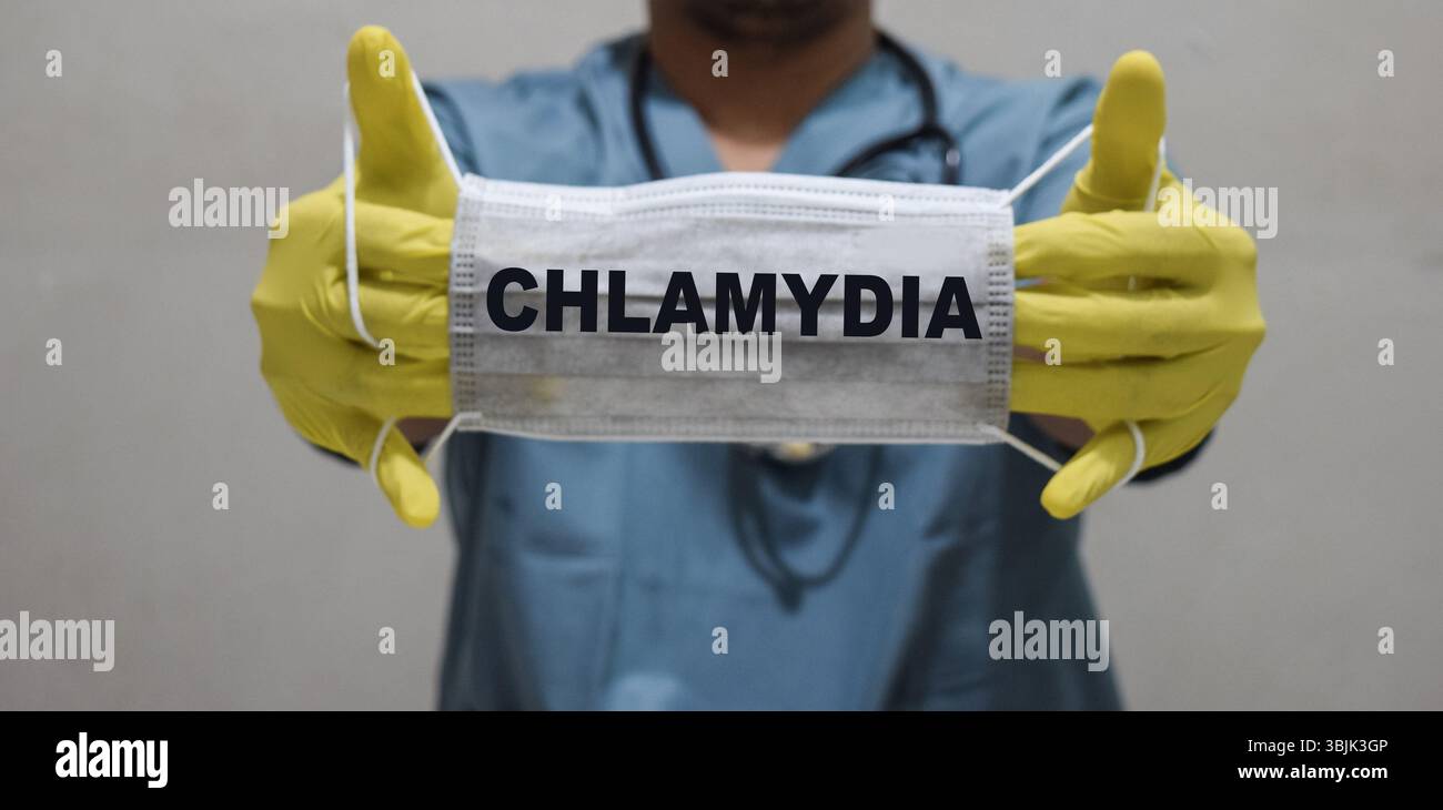 Doctor holds a disposable mask with the text Chlamydia. Medical concept ...