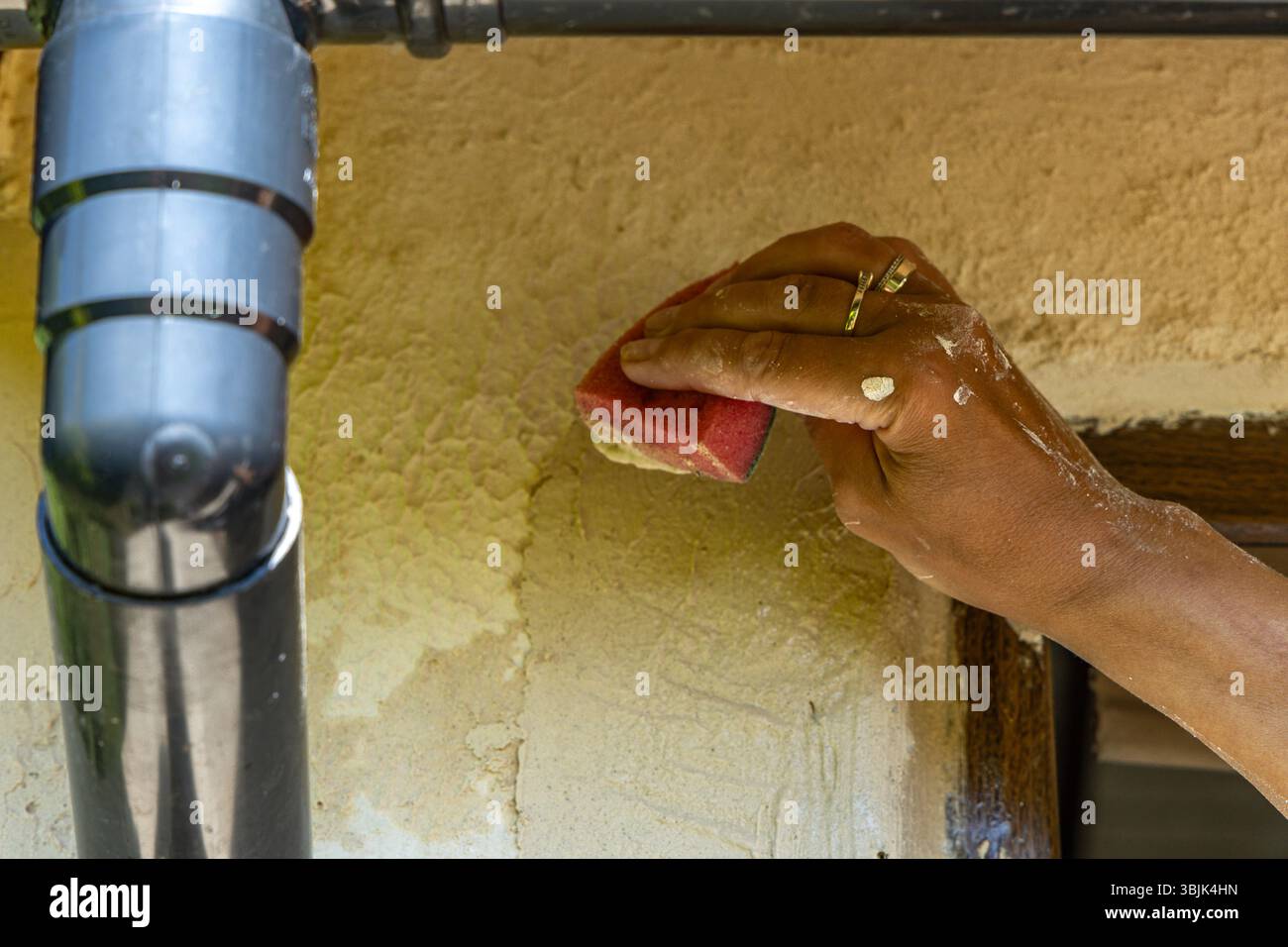 Repair of damaged building facade, application of white decorative ...