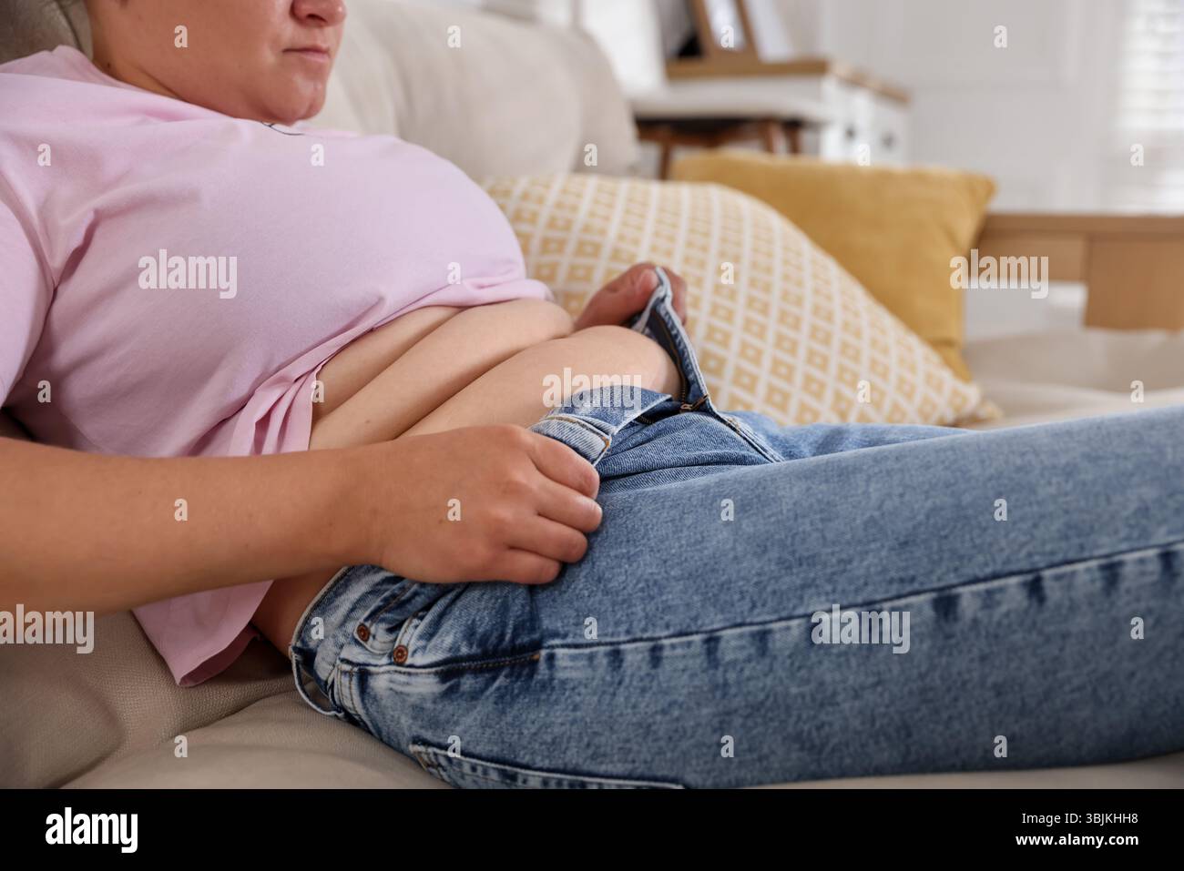 Overweight woman trying to put on tight jeans at home, closeup Stock ...