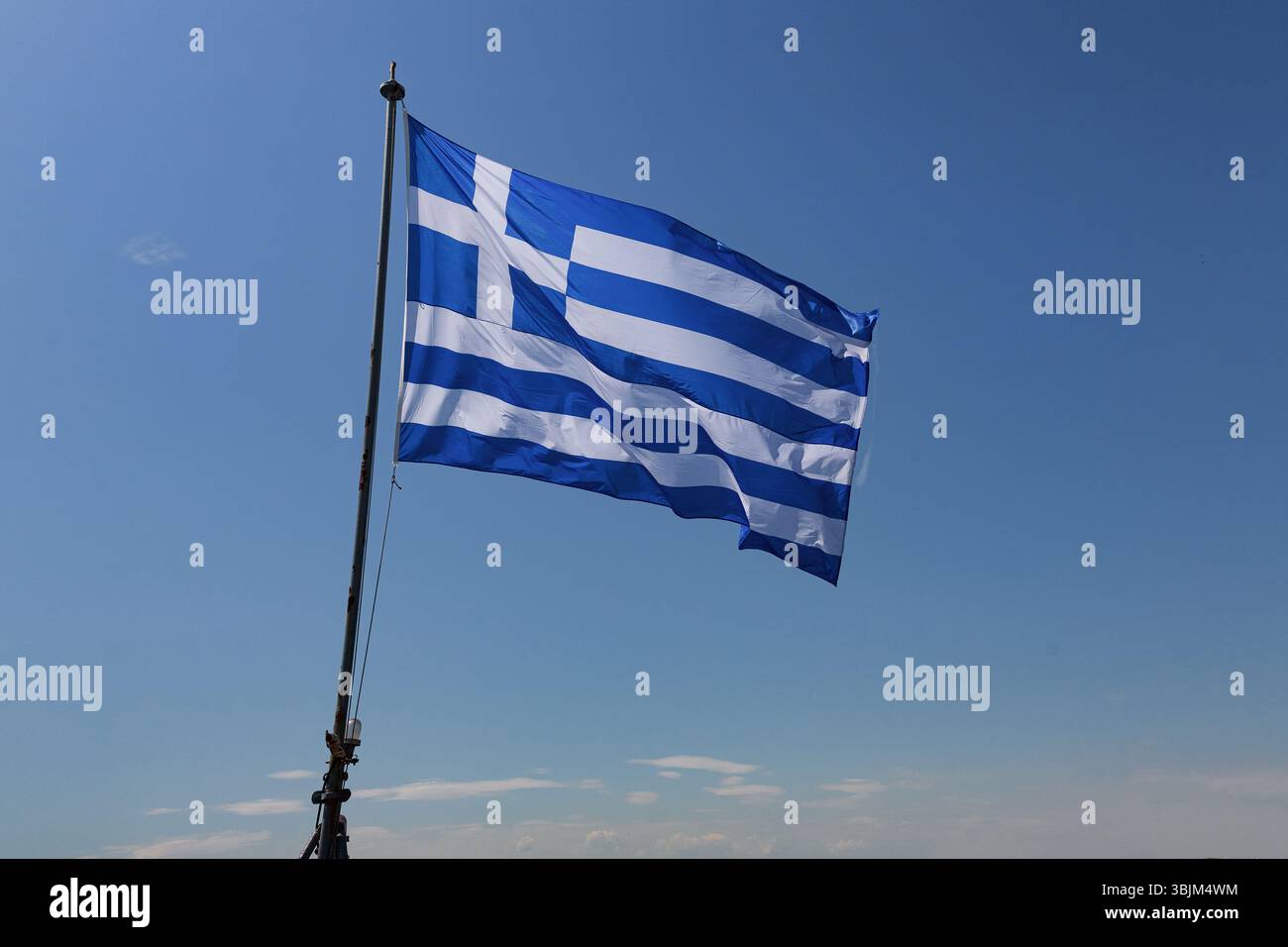 Greek national flag waving wide against cloudless blue sky at sea Stock ...