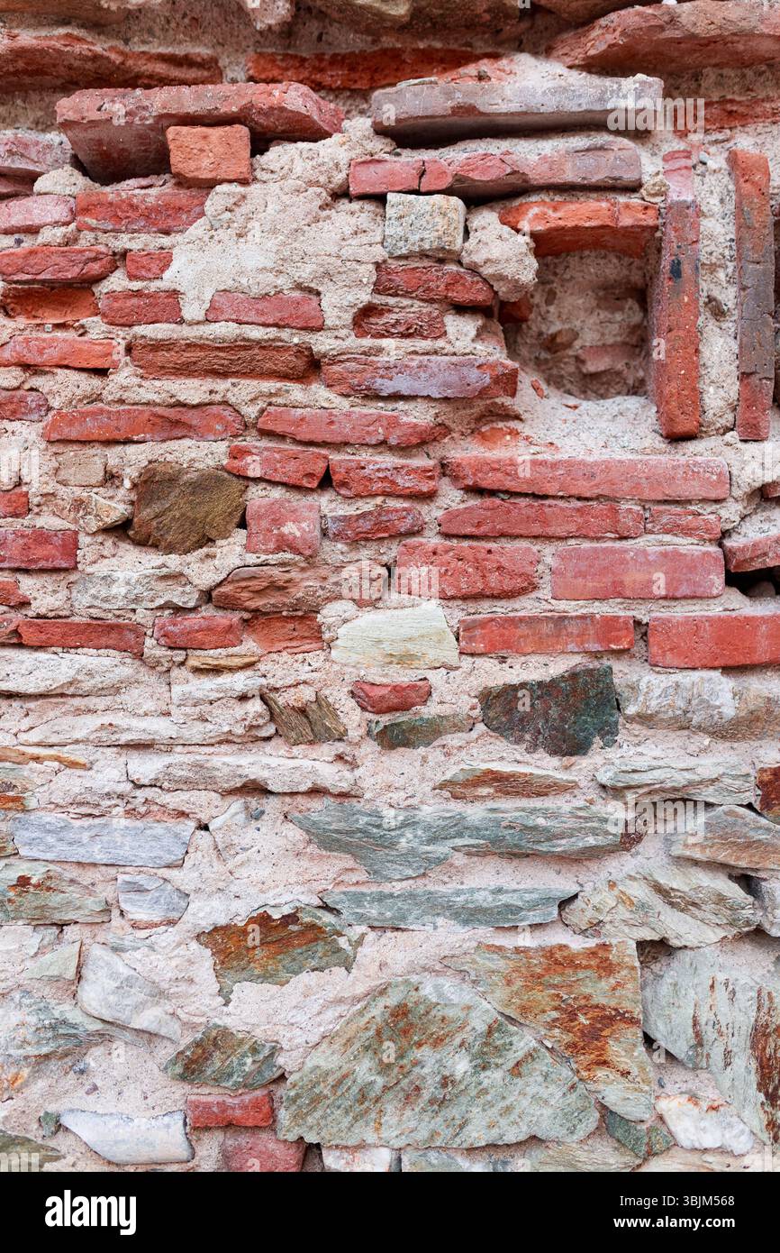 Closeup textured brick wall with ancient layered stone and red masonry ...
