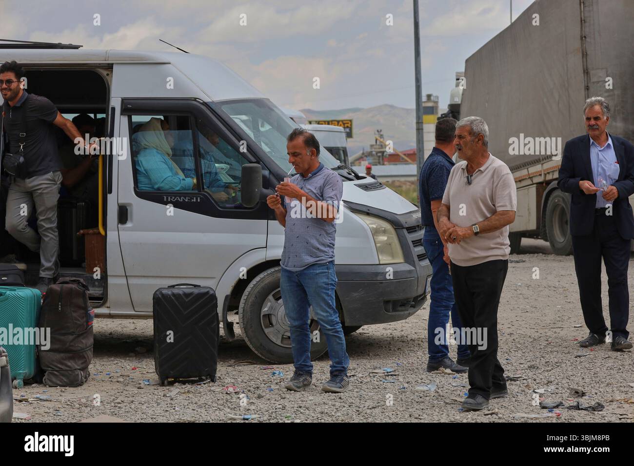 People wait after crossing from Iran into Turkey at Gurbulak Bazargan ...