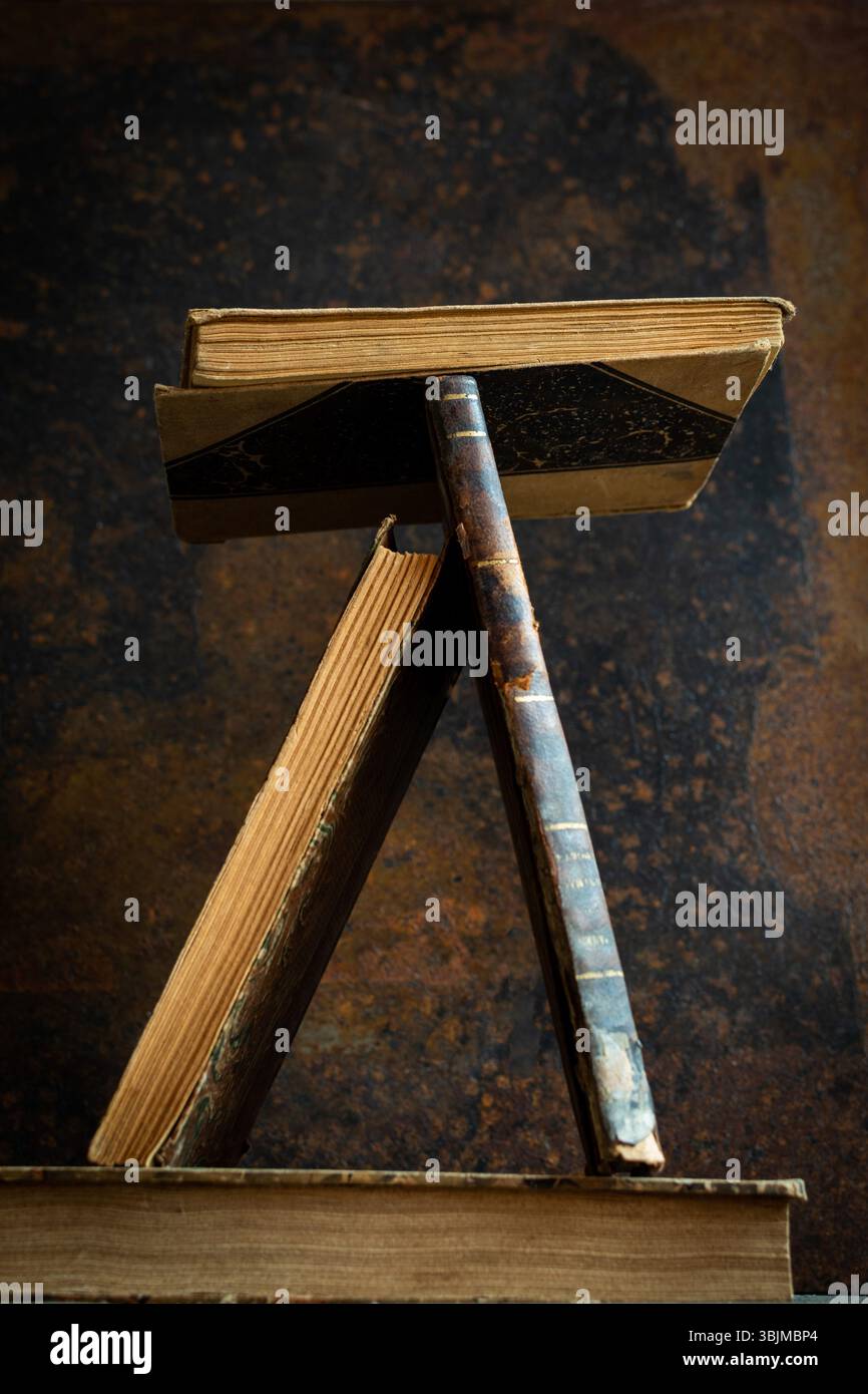A vintage book stand showcases several old books in a unique position ...