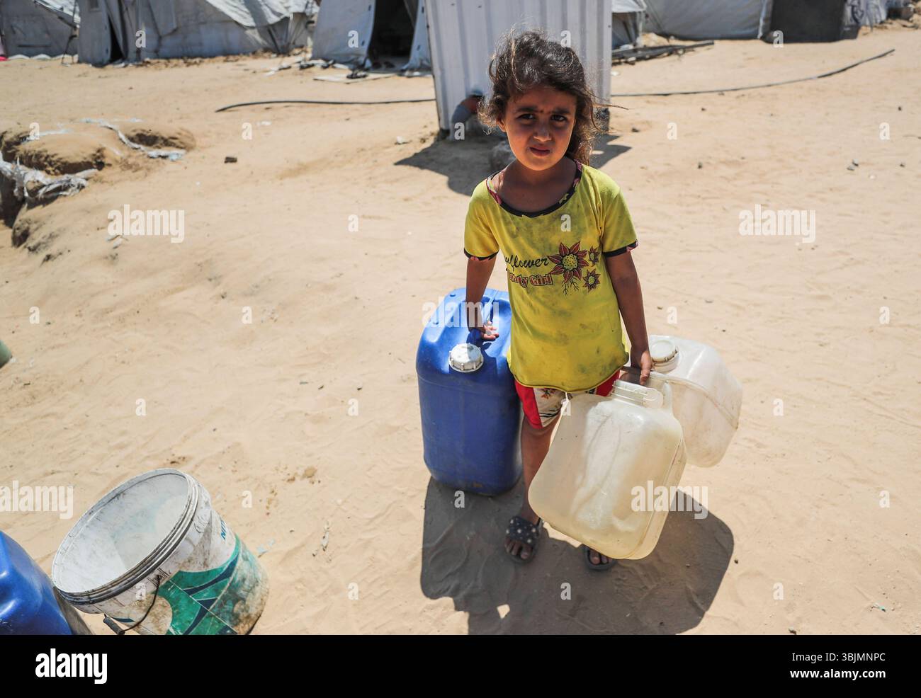 Palestinians carry jerry cans filled with water distributed by a water ...