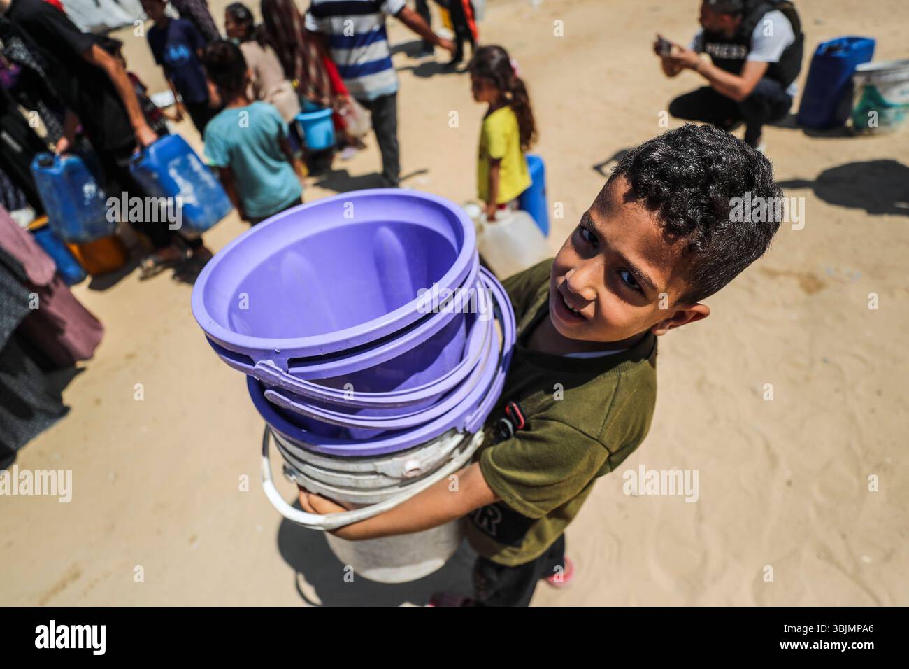 Palestinians carry jerry cans filled with water distributed by a water ...