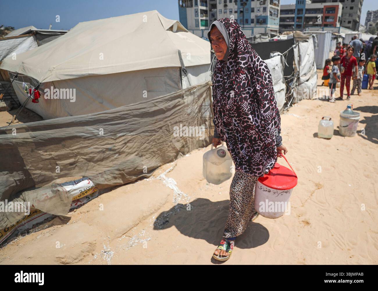Palestinians carry jerry cans filled with water distributed by a water ...