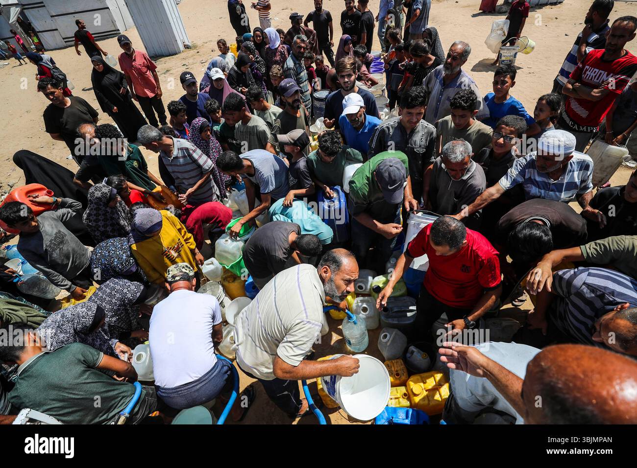 Palestinians carry jerry cans filled with water distributed by a water ...