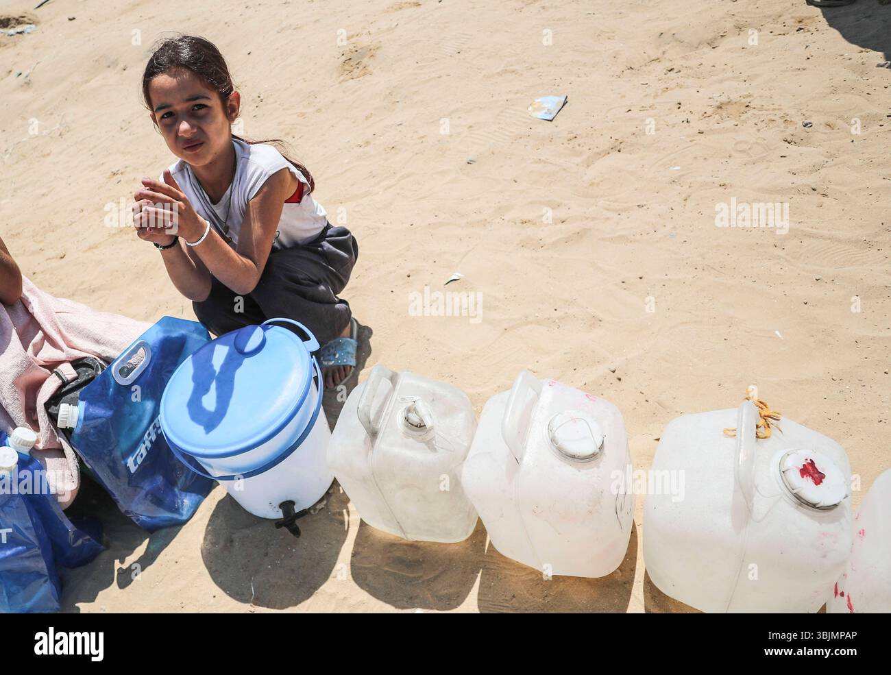 Palestinians carry jerry cans filled with water distributed by a water ...