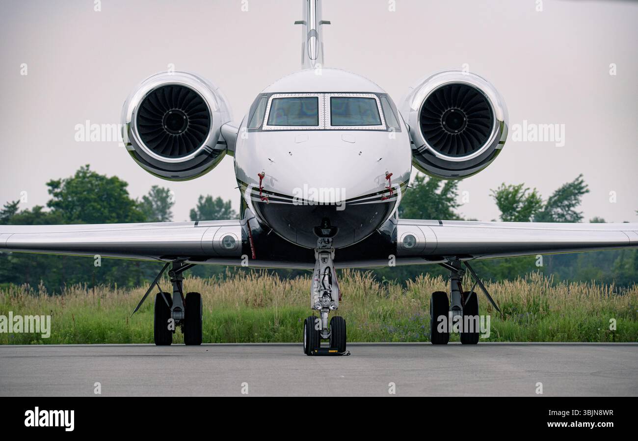 Front view of a sleek private jet on an airfield, ready for departure ...