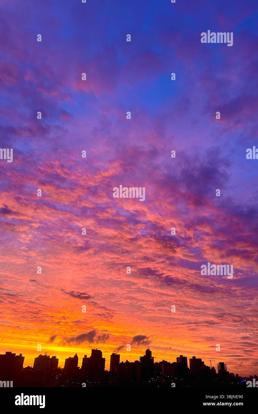 Dramatic sunset sky over city with vivid purple, red, and orange colors ...