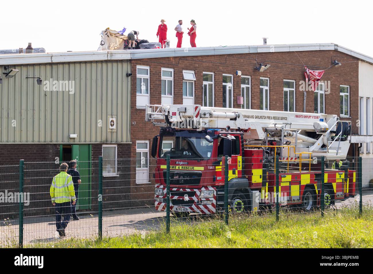 Newton Aycliffe, UK. 16 JUN, 2025. Activists stand on the roof ready to be removed the the fire ...
