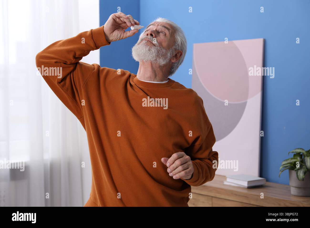 Senior man applying eye drops at home Stock Photo - Alamy