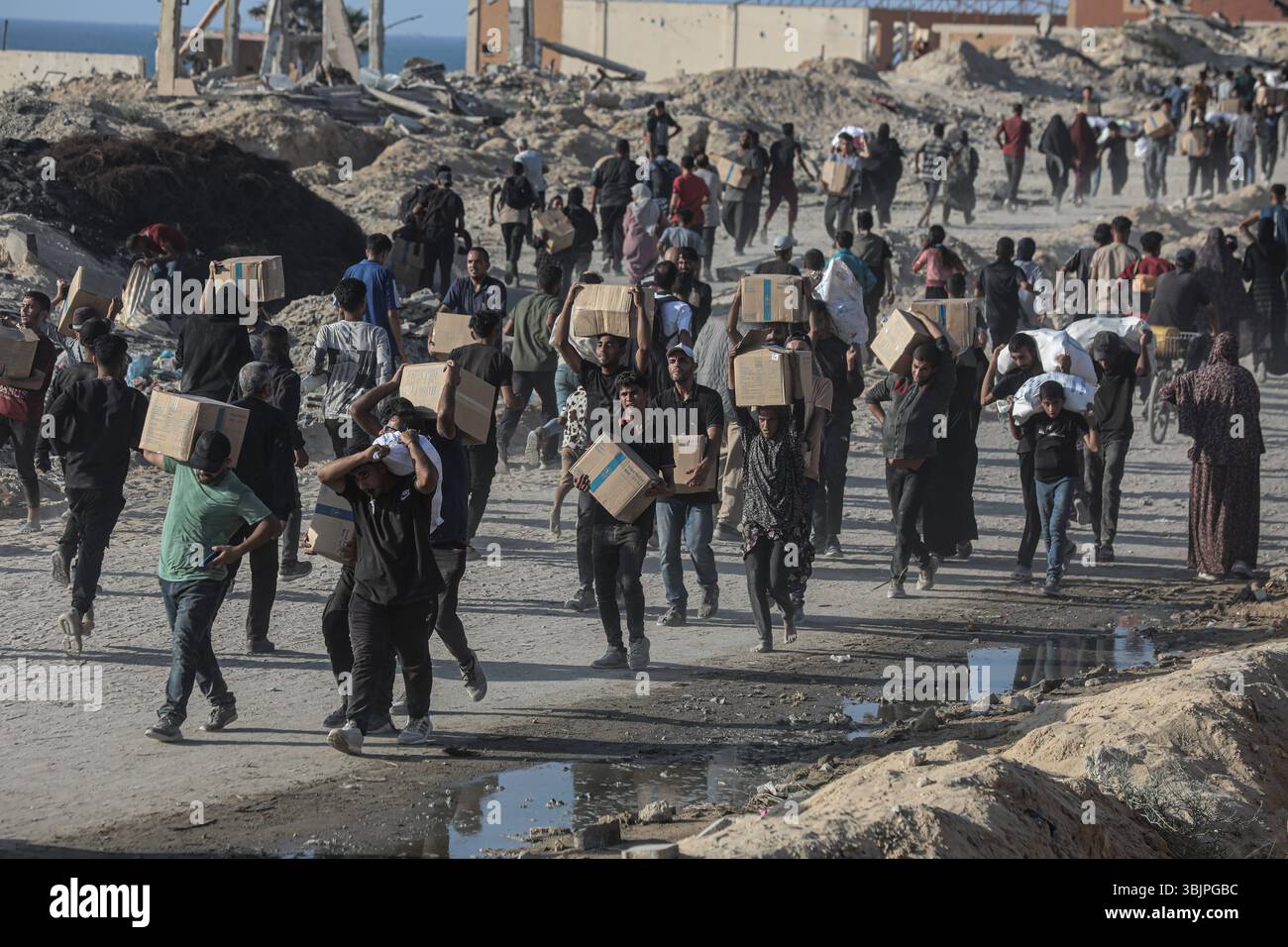 Palestinians carry food parcel, distributed by Gaza Humanitarian Relief ...