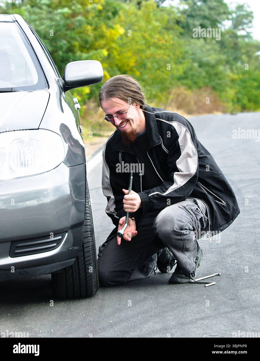 Handsome young man repairing flat tire hi-res stock photography and ...