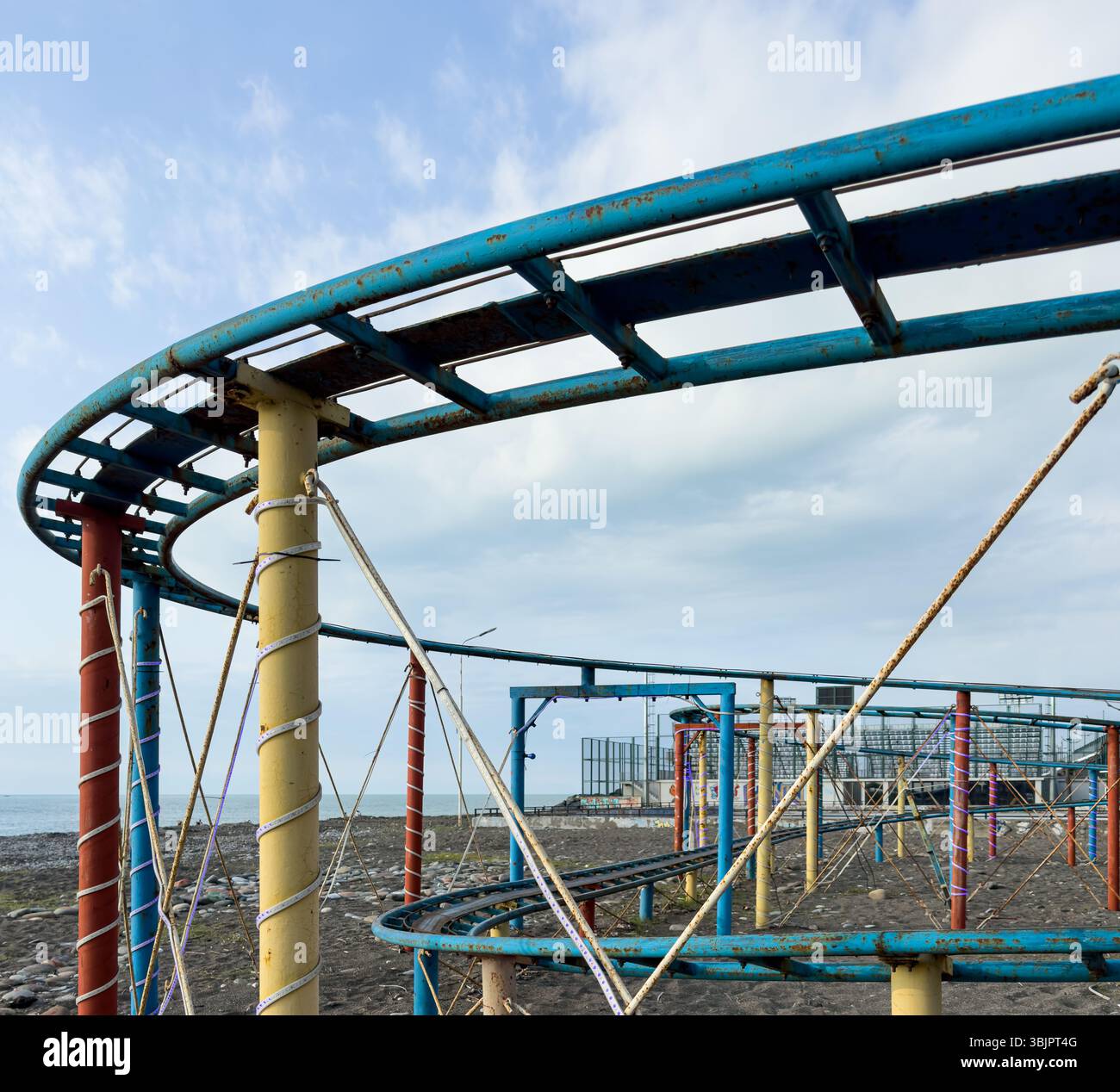 Close-up of a rusty roller coaster structure with colorful support ...