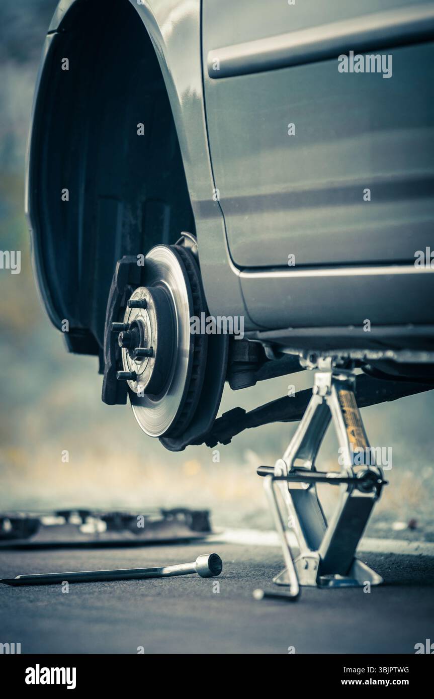 Car without tire on the road Stock Photo - Alamy