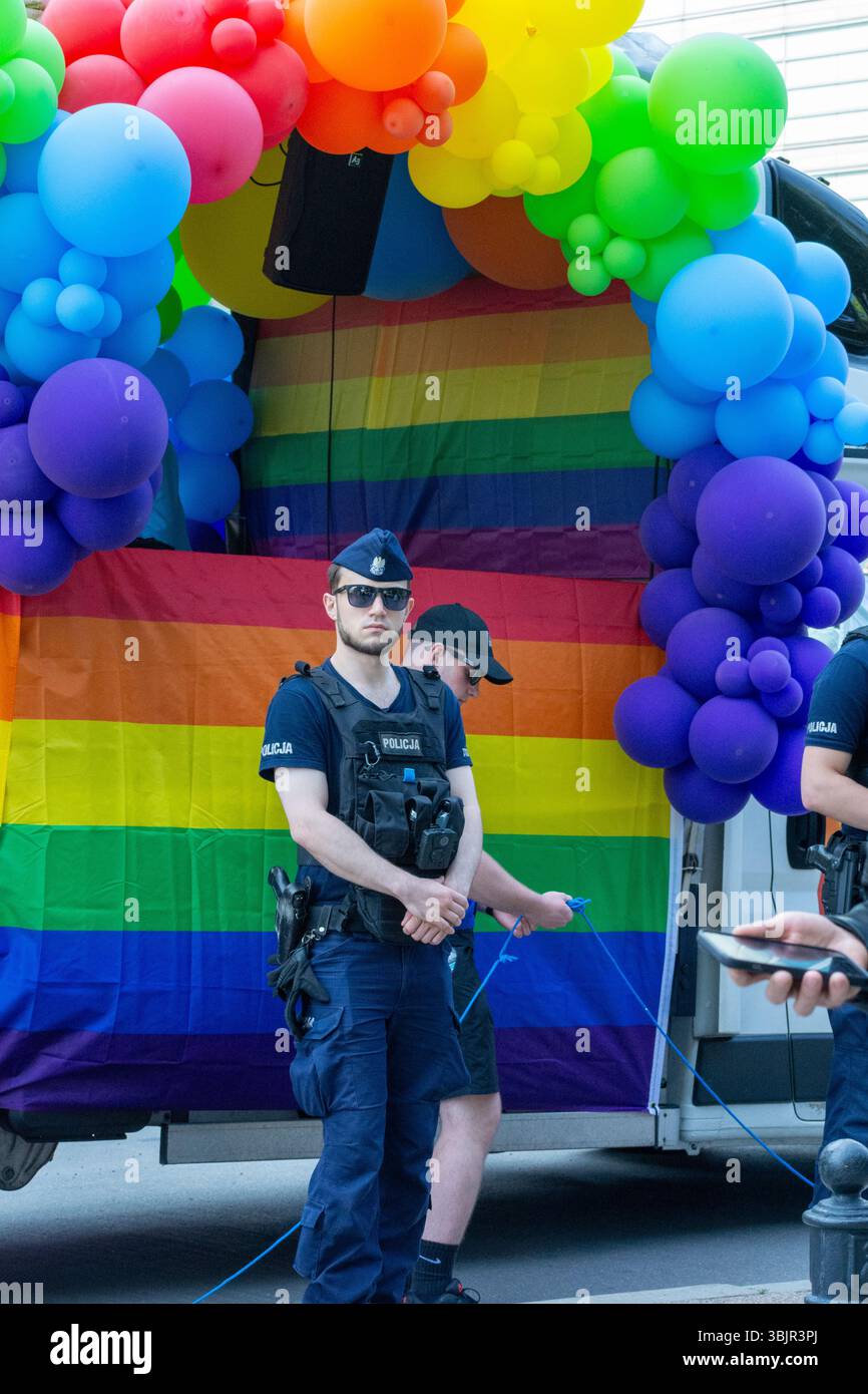 Uniformed police officers stand guard in front of a rainbow balloon ...