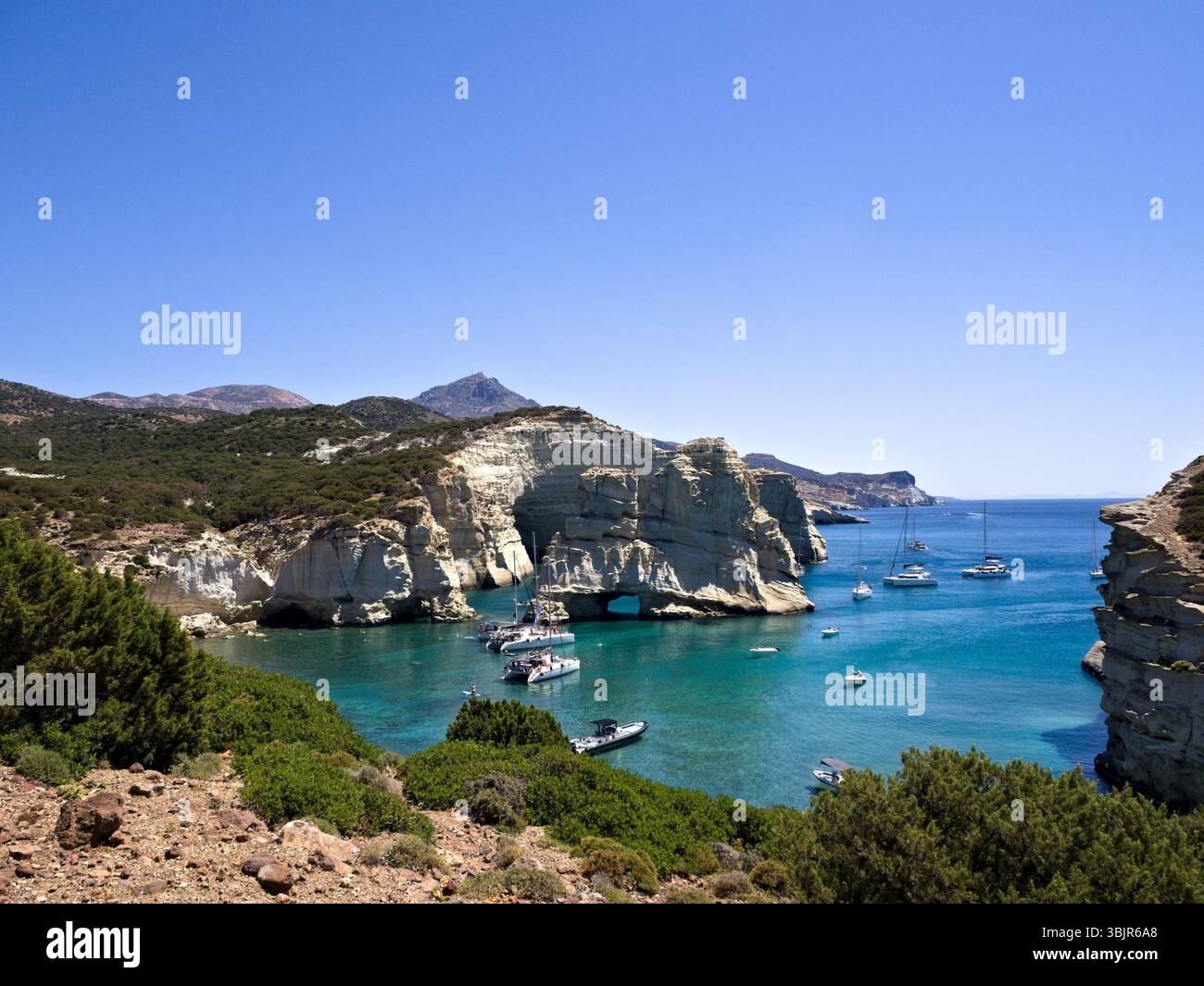 Scenic panoramic photo of Kleftiko bay, with boats in clear sea ...