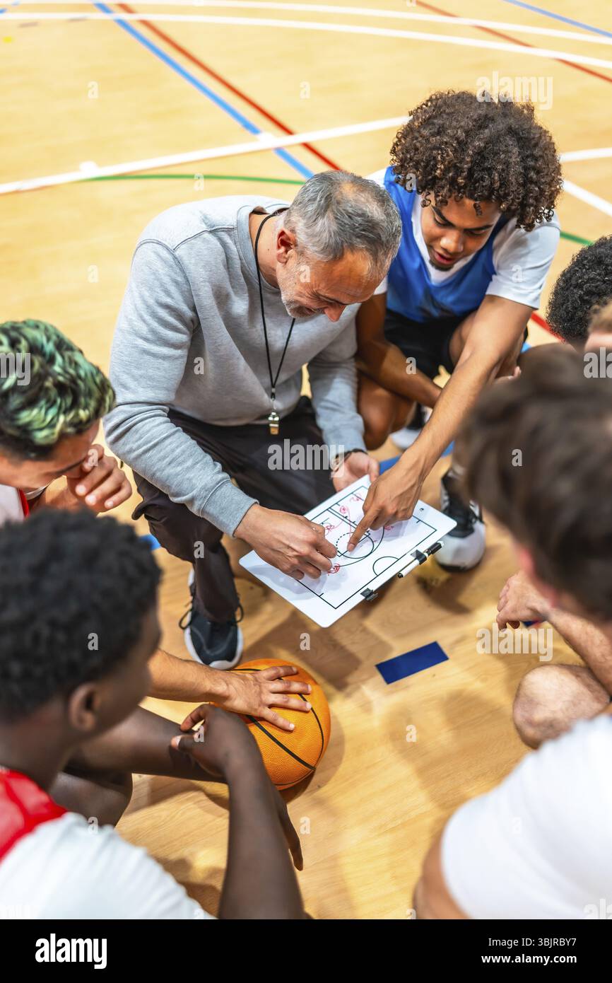 Basketball coach discussing game strategy with team players during a ...