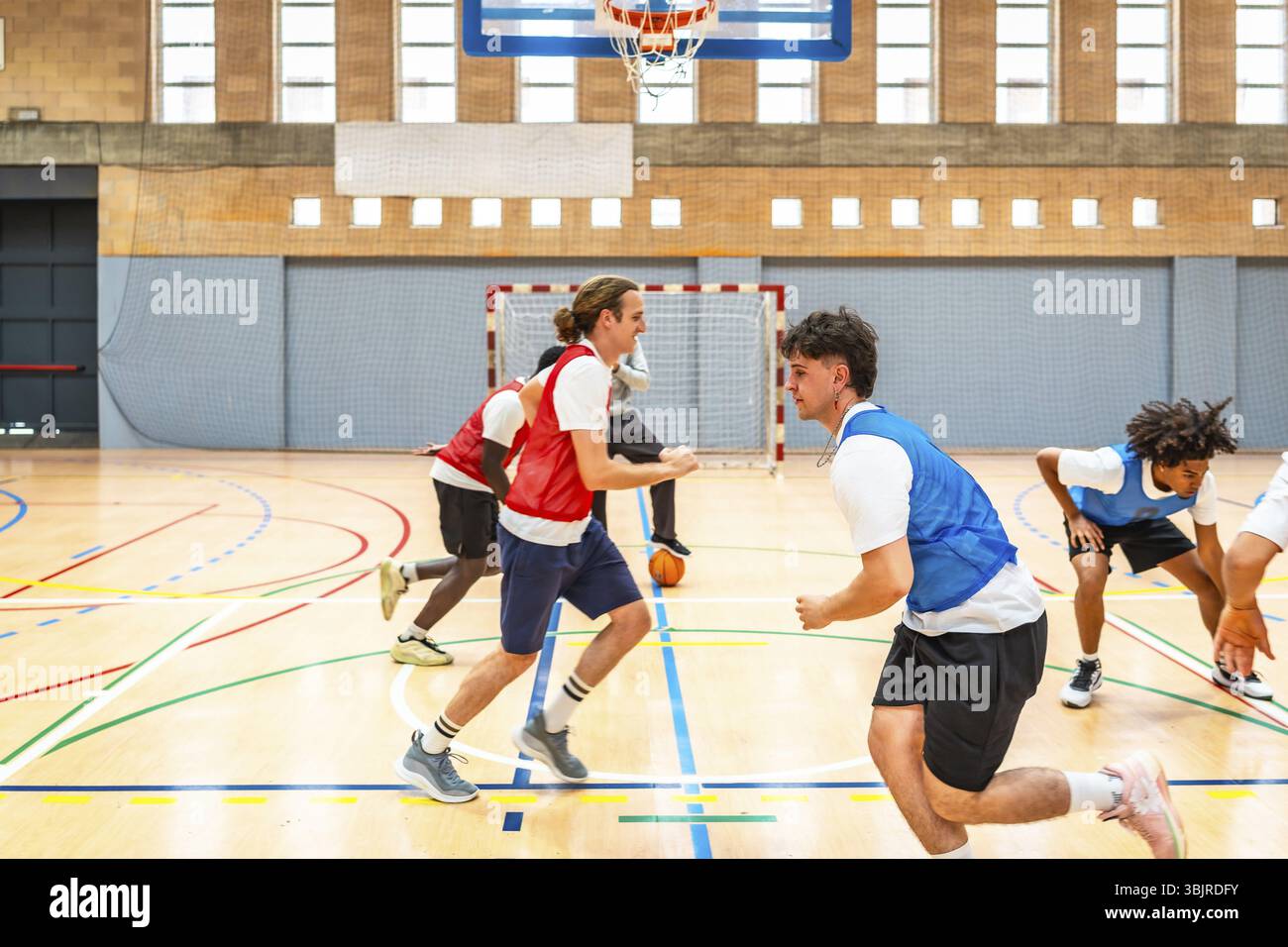 Basketball players running and practicing in a gymnasium, showcasing ...