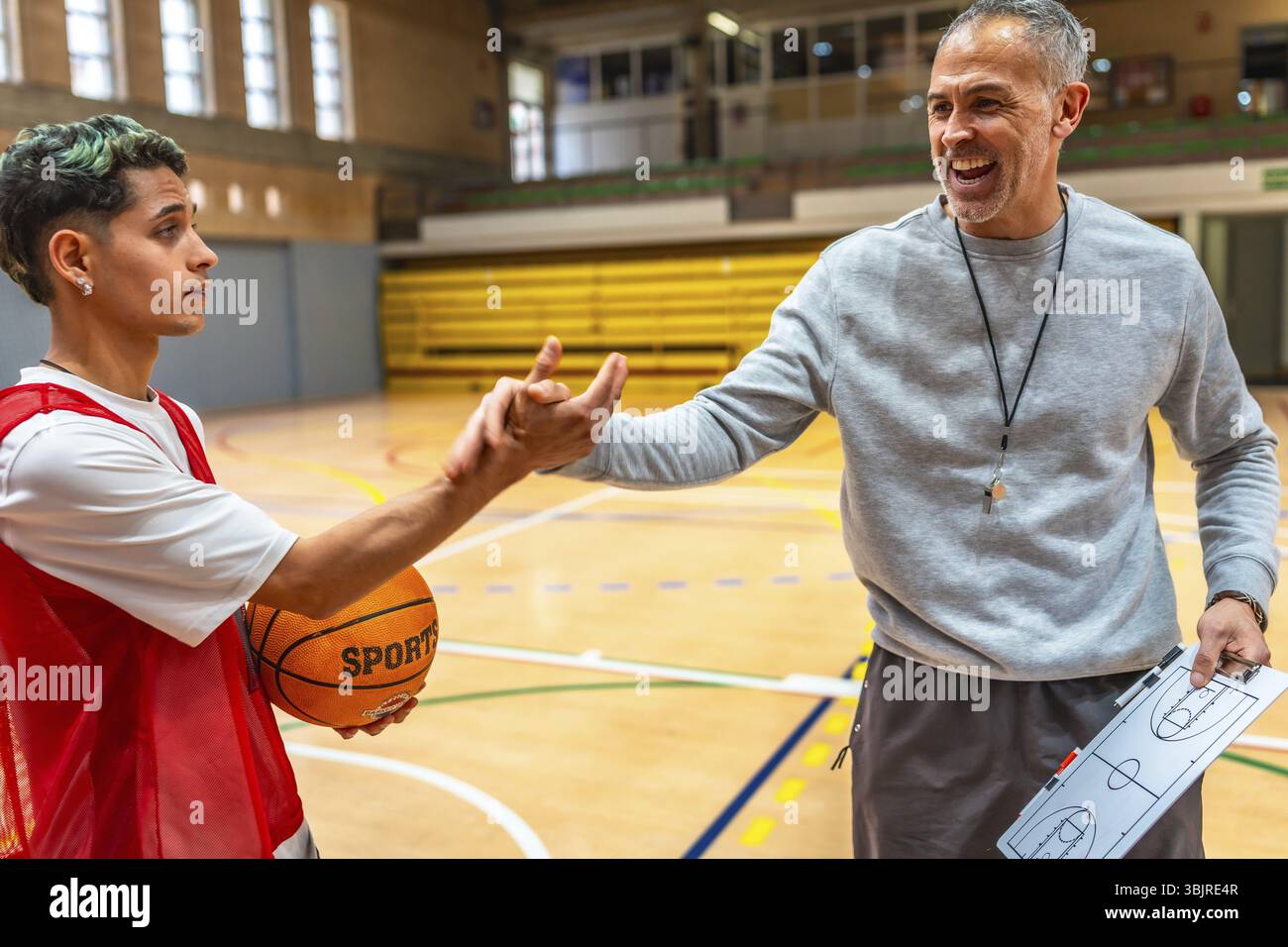 Basketball coach explaining game strategy using clipboard to young ...