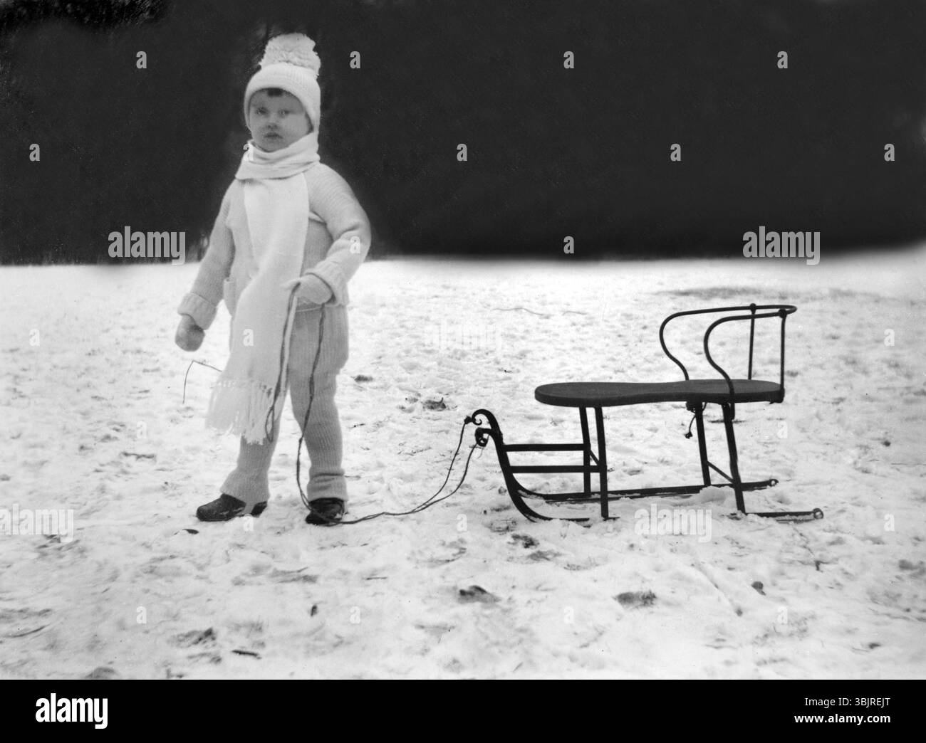 Child with sledge, 1930s, Child in winter clothes with cap and scarf ...
