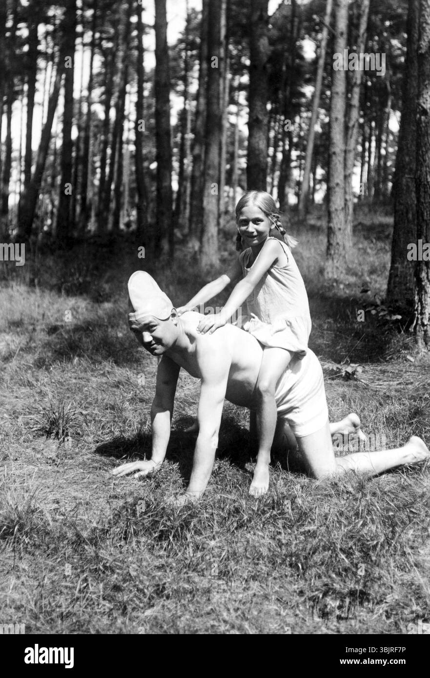 Girl Riding On Her Fathers Back 1930s A Girl Rides Happily On A Man