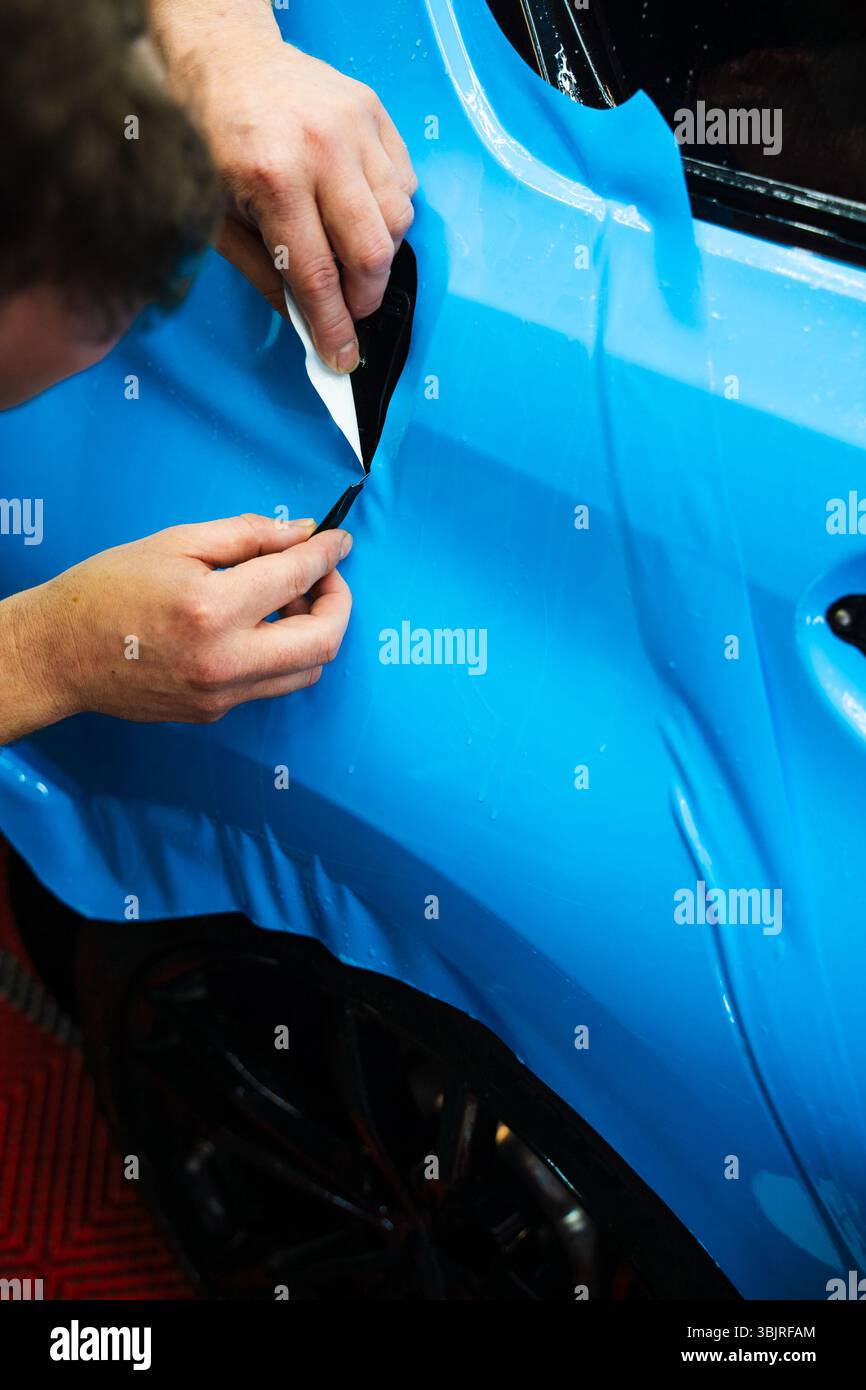 Cutting blue PPF with blade. Cutting blue paint protection film with ...