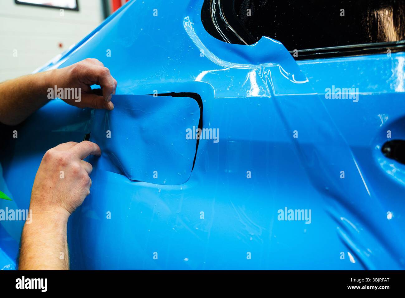 Cutting blue PPF with blade. Cutting blue paint protection film with ...