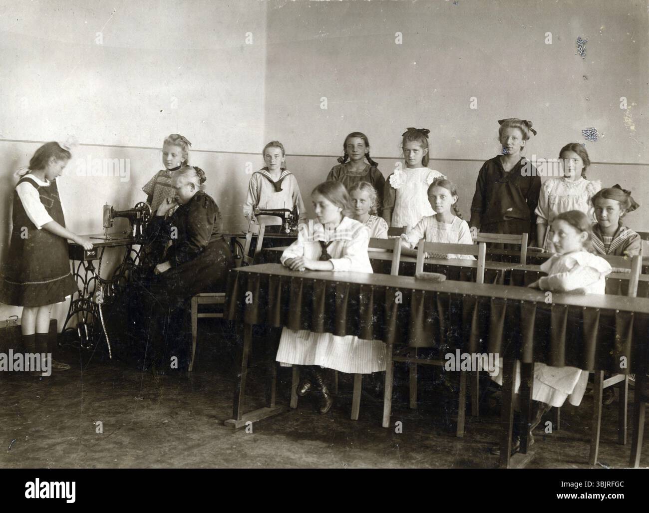 Sewing class at school, 1920, girls in a classroom practising sewing ...