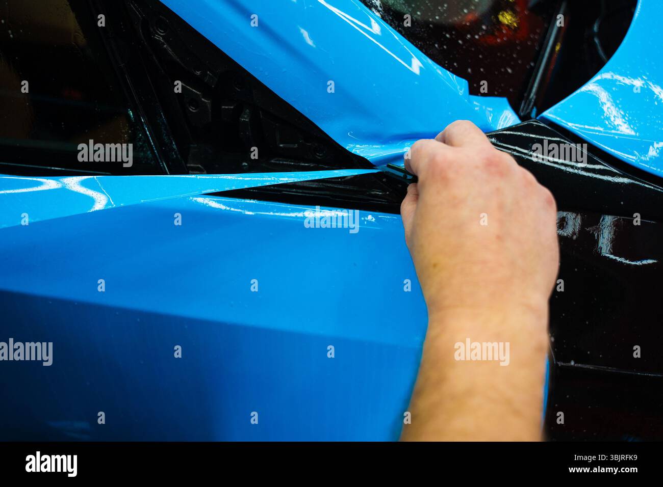 Cutting blue PPF with blade. Cutting blue paint protection film with ...