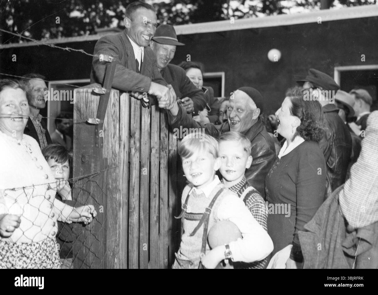 Refugees from the Soviet zone, 1952, A group of people gather around a ...
