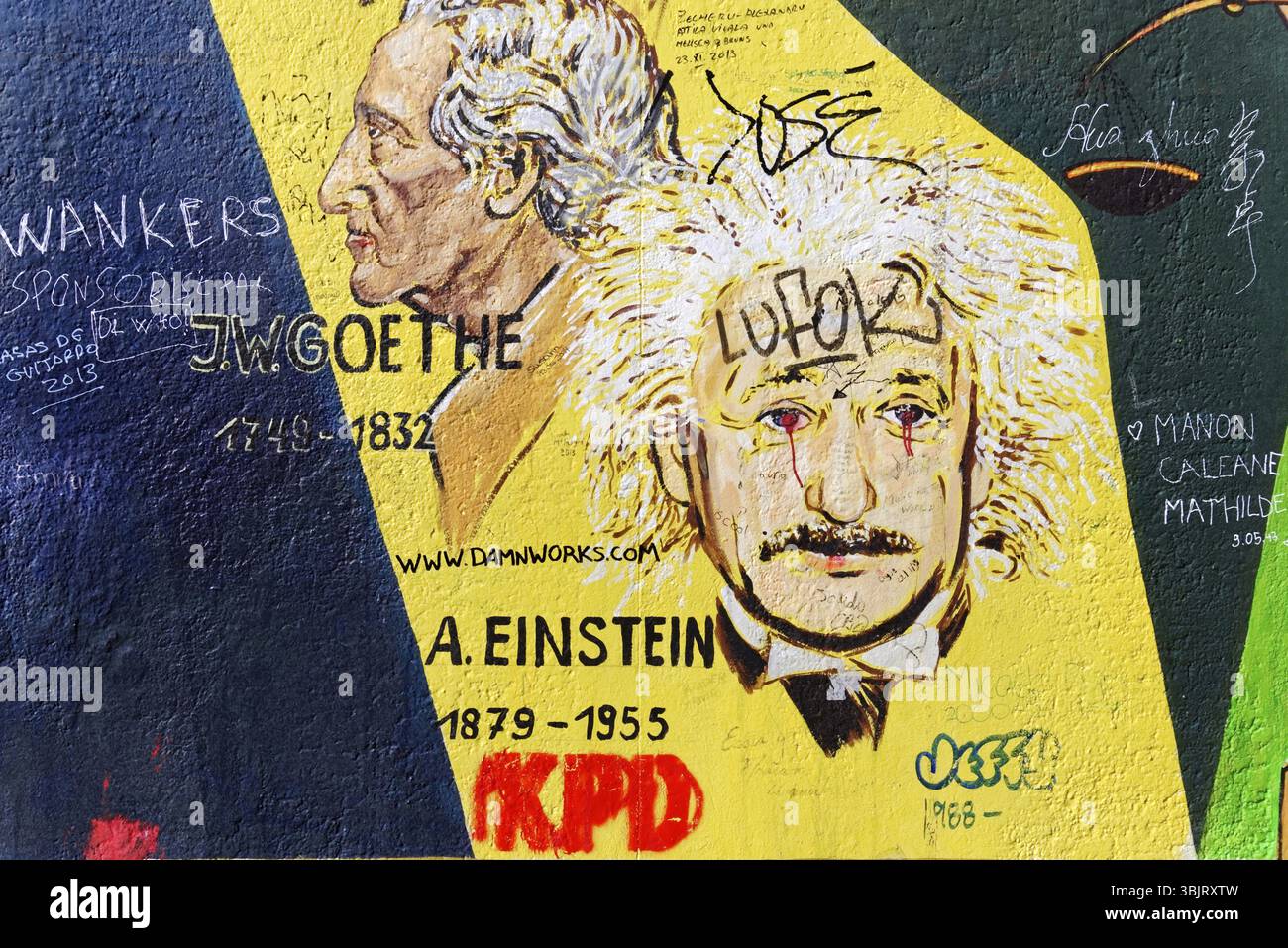 Portraits of Goethe and Einstein on a yellow wall with graffiti writing ...