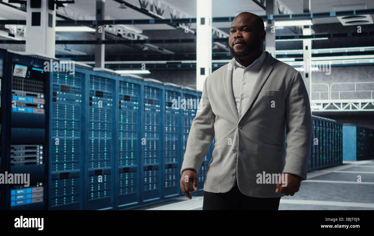 Smiling engineer in server hub monitoring data center energy ...