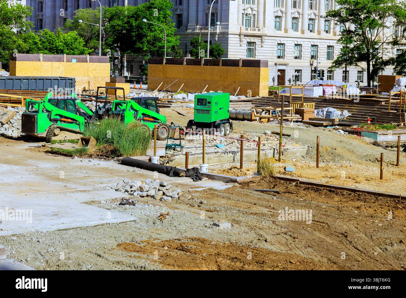 Heavy machinery works on construction site while various materials are ...