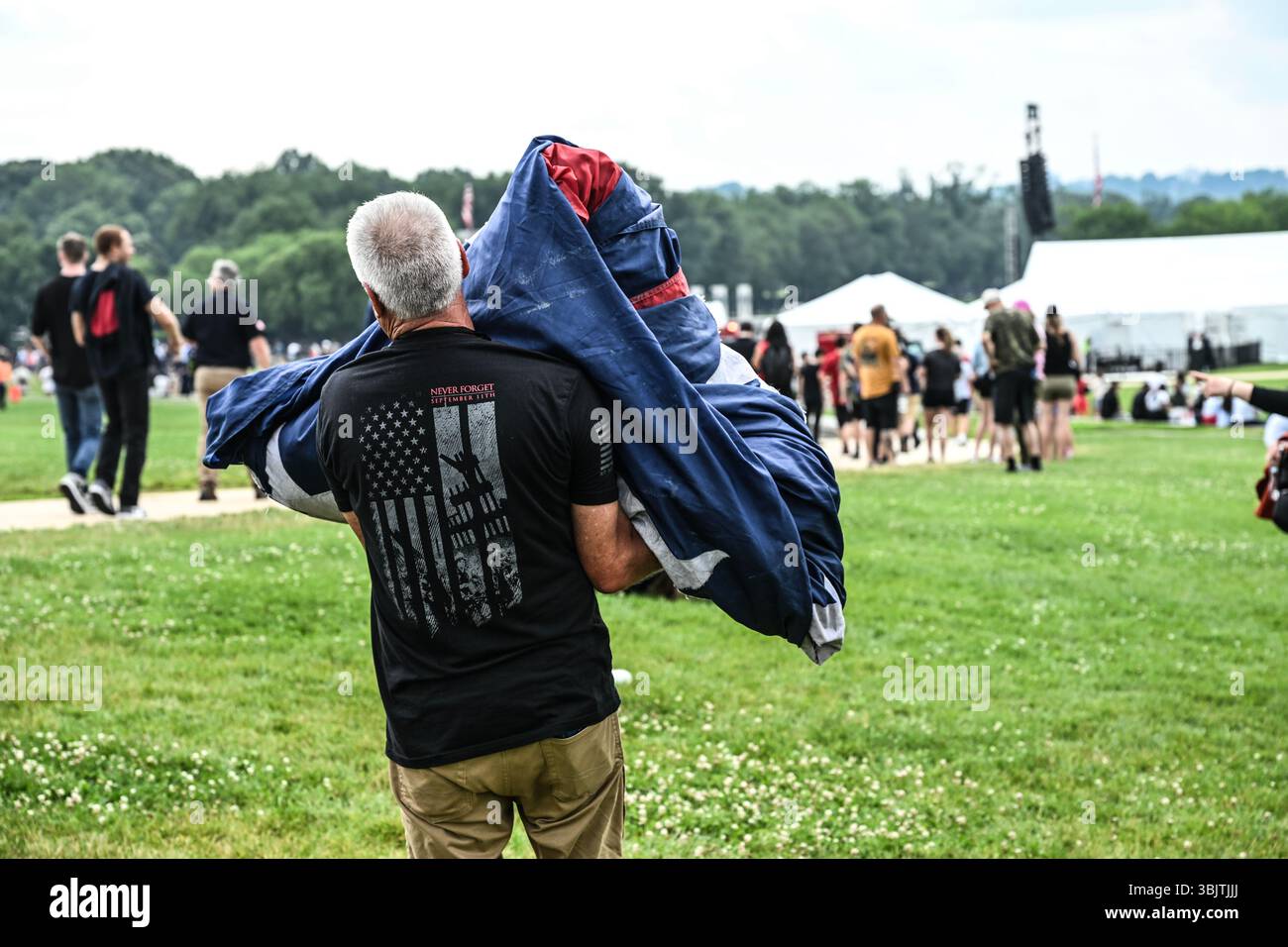 A Trump supporter carries away the giant flag presented on the National ...