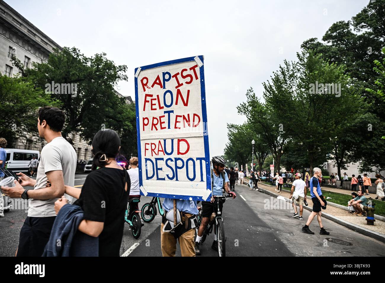 A protester holds a placard during the demonstration. Thousand MAGA ...