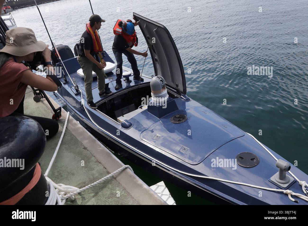 Staff inspect the Unmanned Surface Vehicle (USV) Black Tide, made by ...