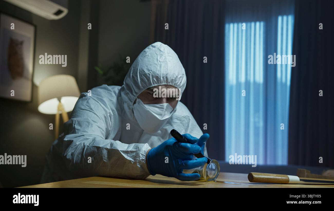 Crime scene investigator in full protective gear examines glass ...