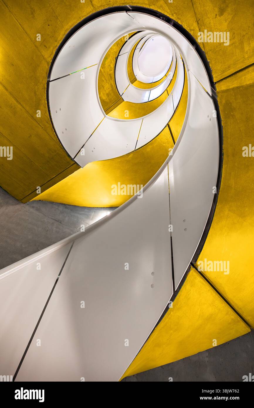 Spiral concrete staircase with yellow color ceiling in a yellow ...