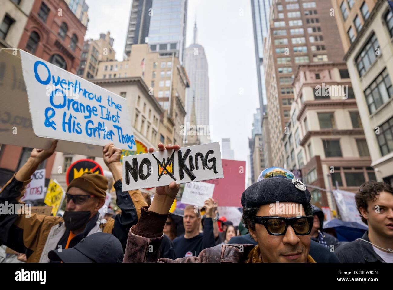 New York, Ny, USA. 14th June, 2025. A person holds a "No kings,"" sign ...
