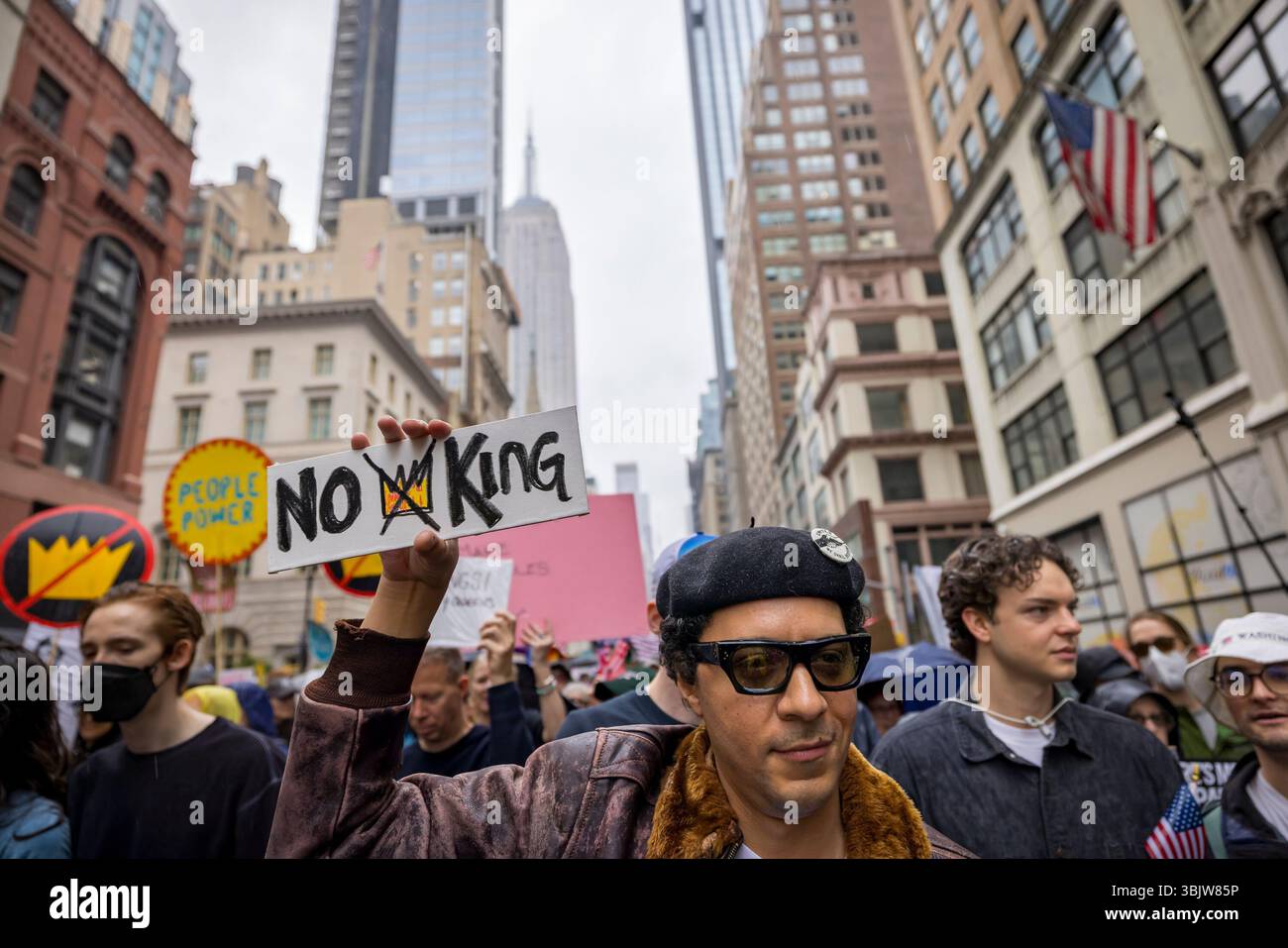 New York, Ny, USA. 14th June, 2025. A person holds a "No kings,"" sign ...